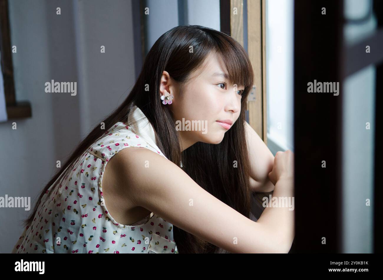 Woman looking out of the window Stock Photo - Alamy