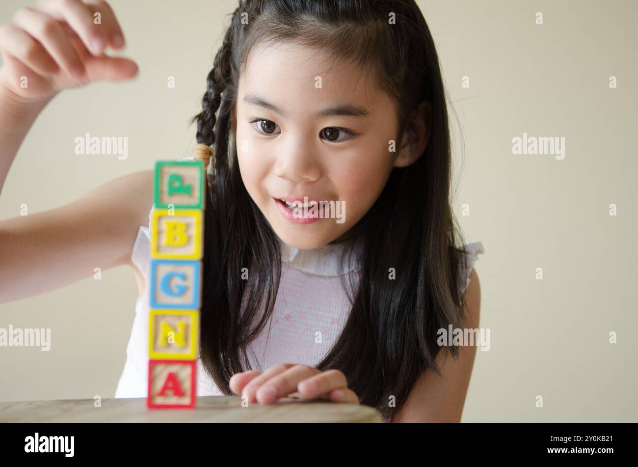 Girl playing with alphabet building blocks Stock Photo - Alamy