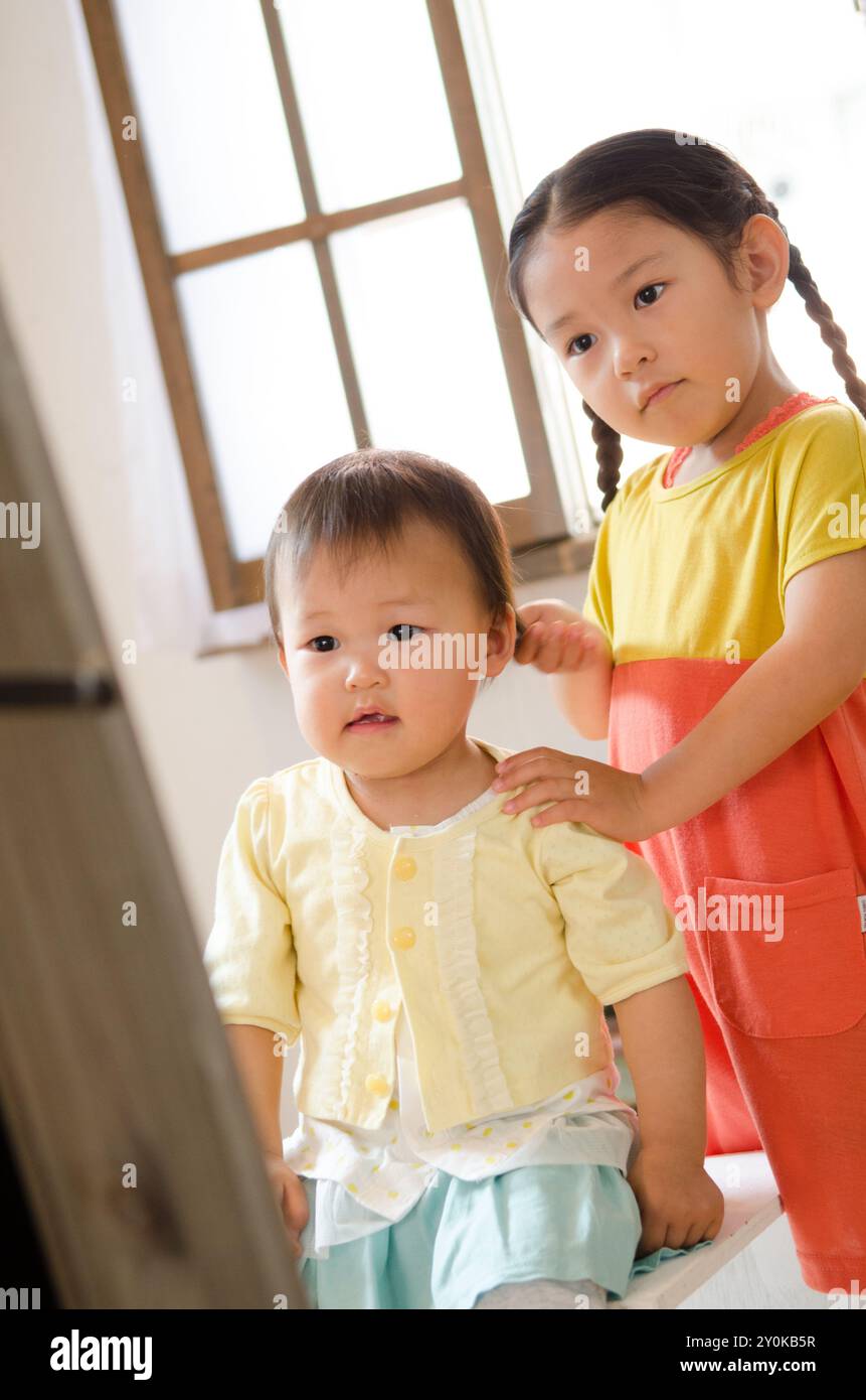 Sisters who are playing beauty parlor game Stock Photo - Alamy
