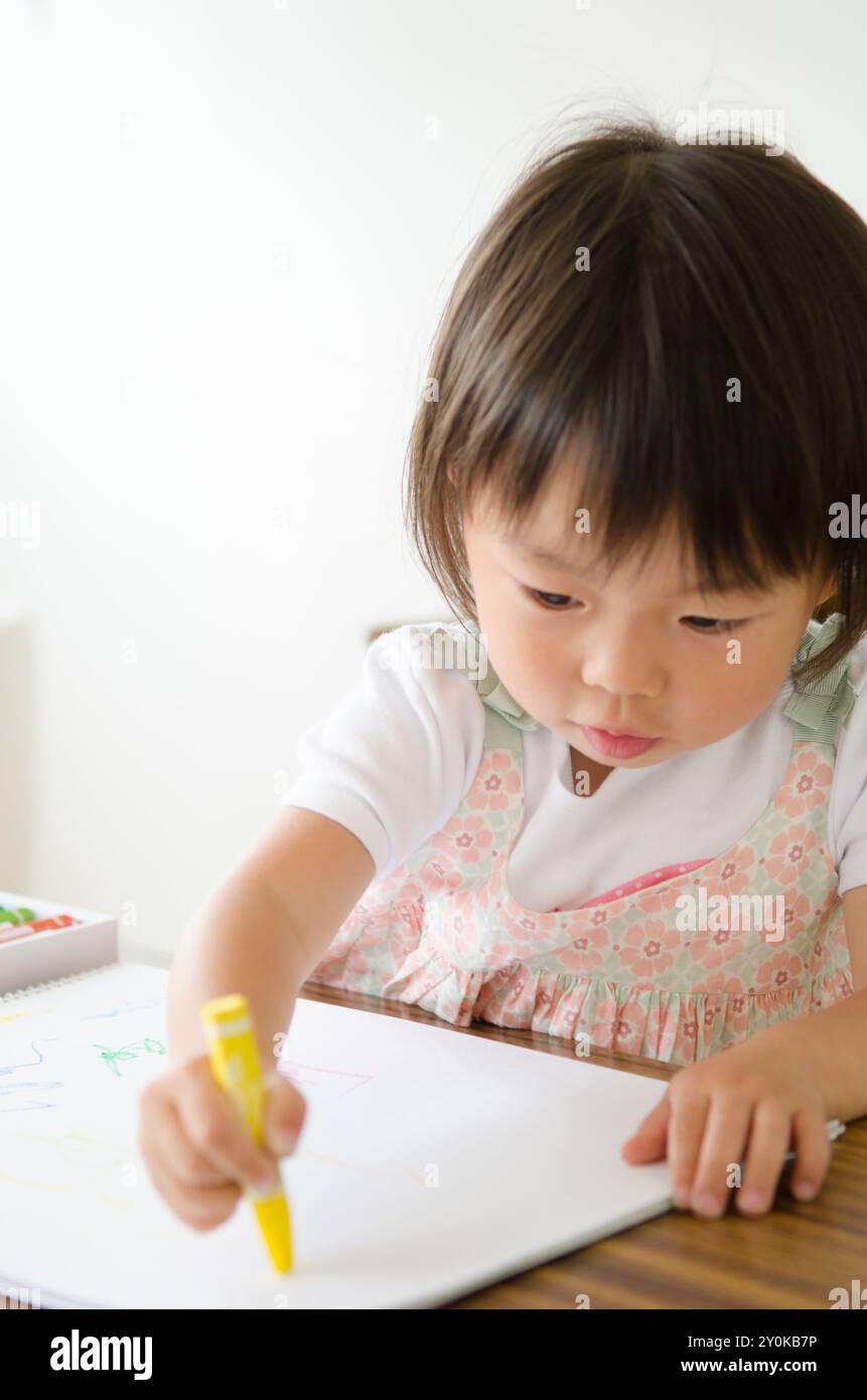 The girl drawing with crayons Stock Photo - Alamy