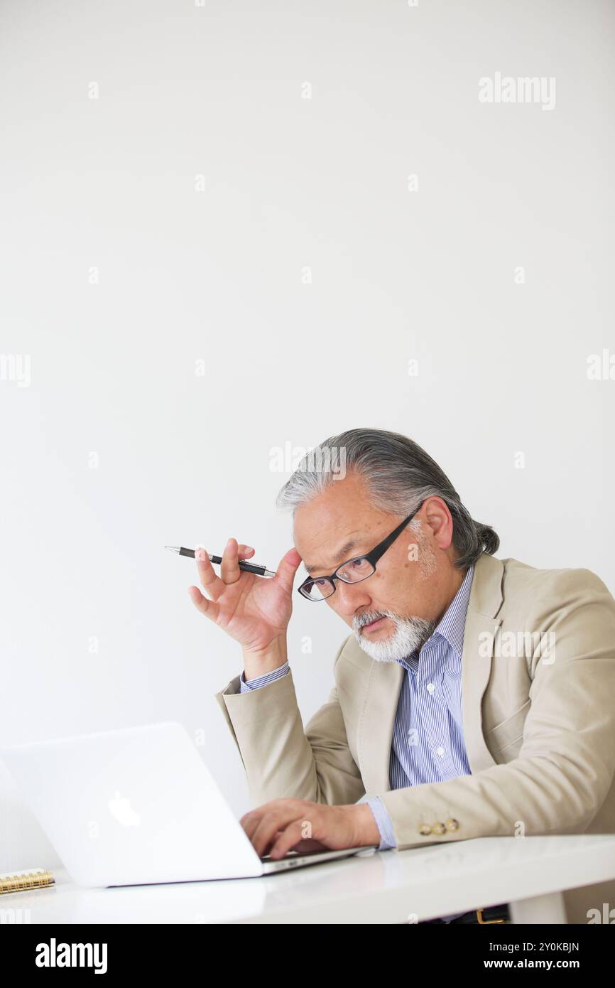 Senior man operating computer at the desk Stock Photo - Alamy