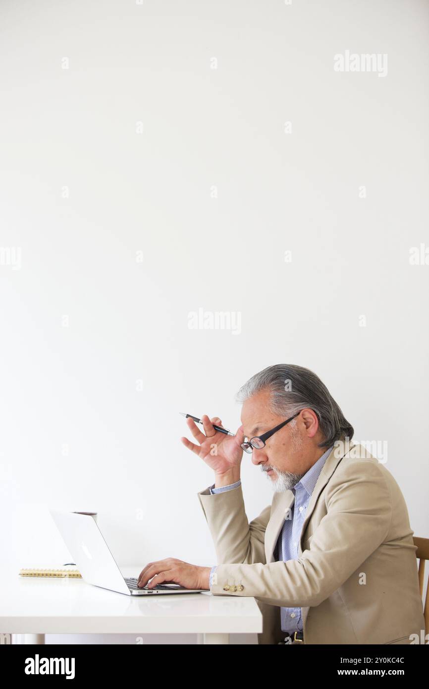 Senior man operating computer at the desk Stock Photo - Alamy