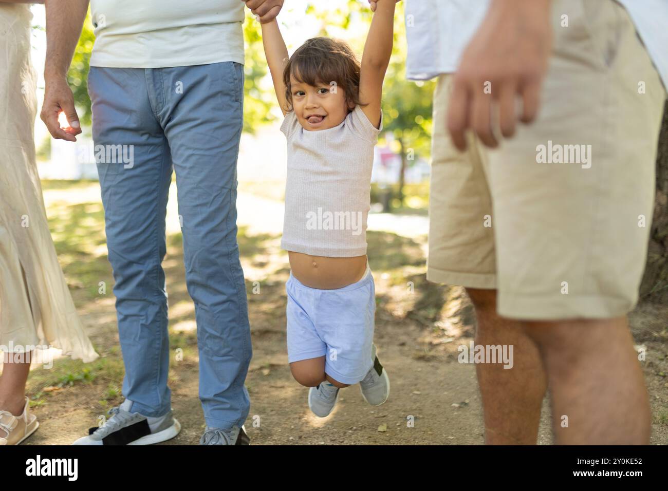 Happy family lifting little boy while walking in park Stock Photo - Alamy