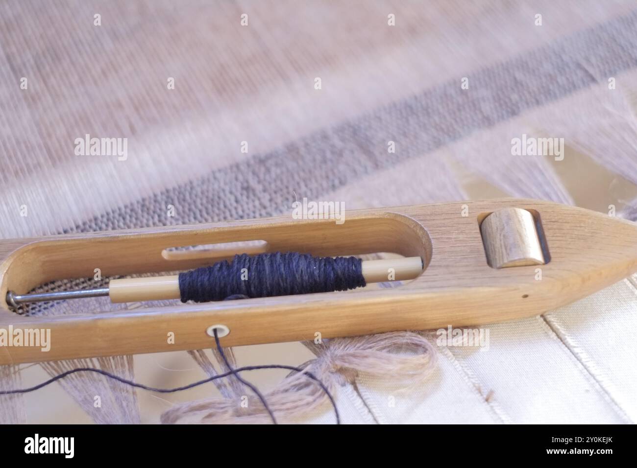 Woven textile and shuttle in the process of weaving Stock Photo - Alamy