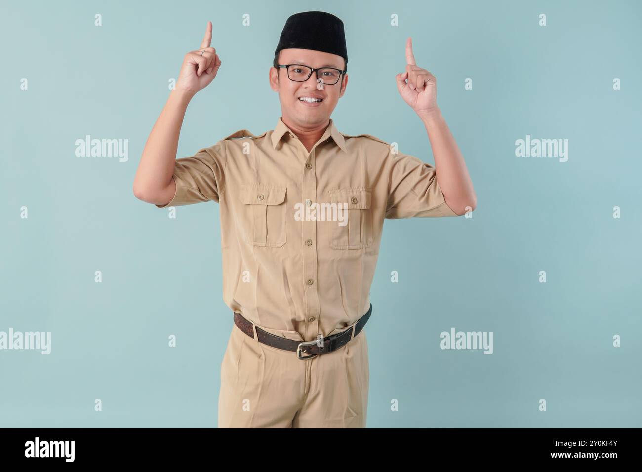 Smiling Indonesian government worker man wearing khaki uniform pointing ...