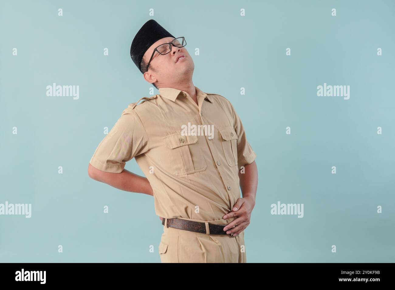Tired Indonesian government worker man wearing khaki uniform suffering ...