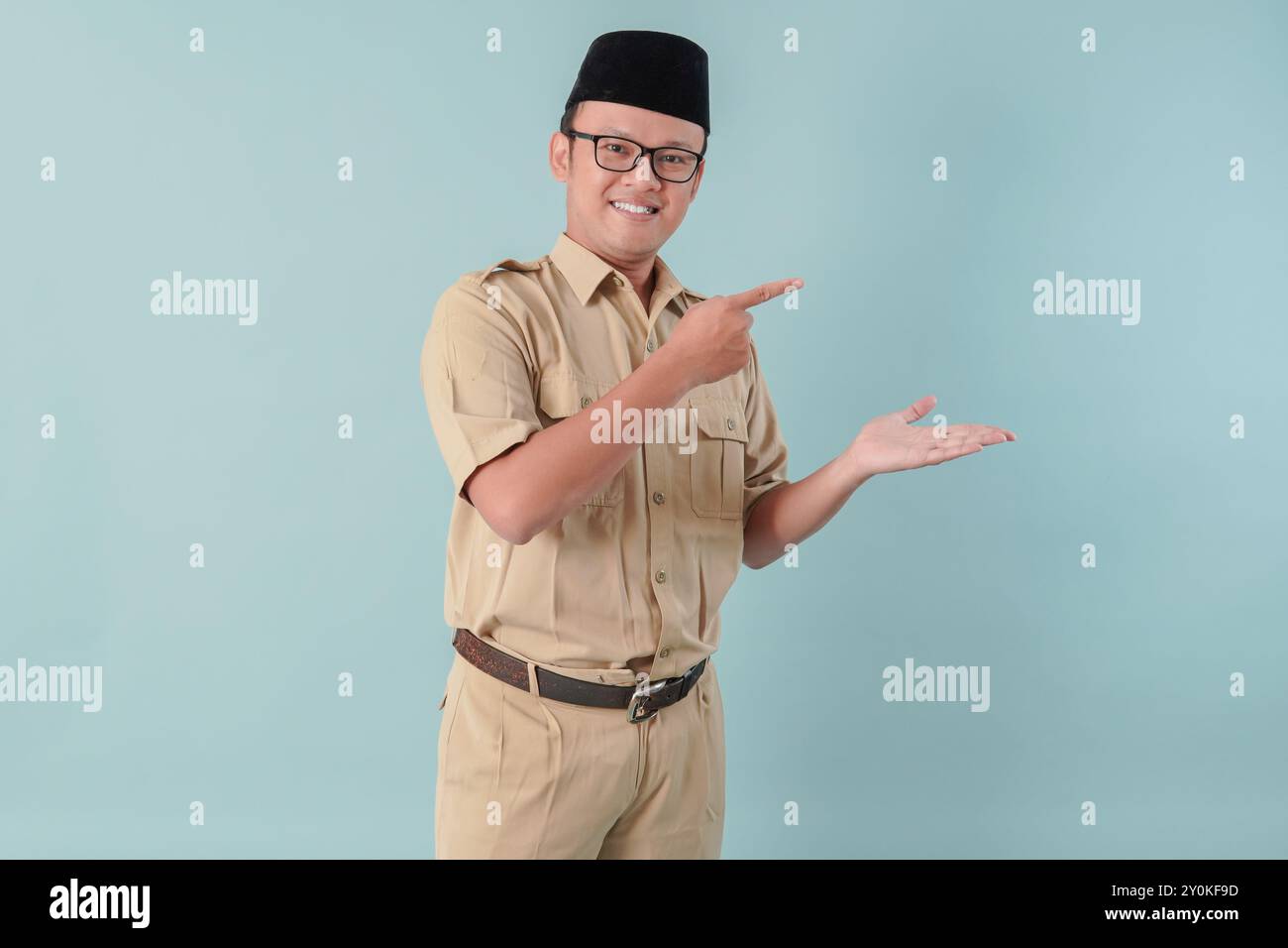 Happy Indonesian government worker man wearing khaki uniform pointing ...