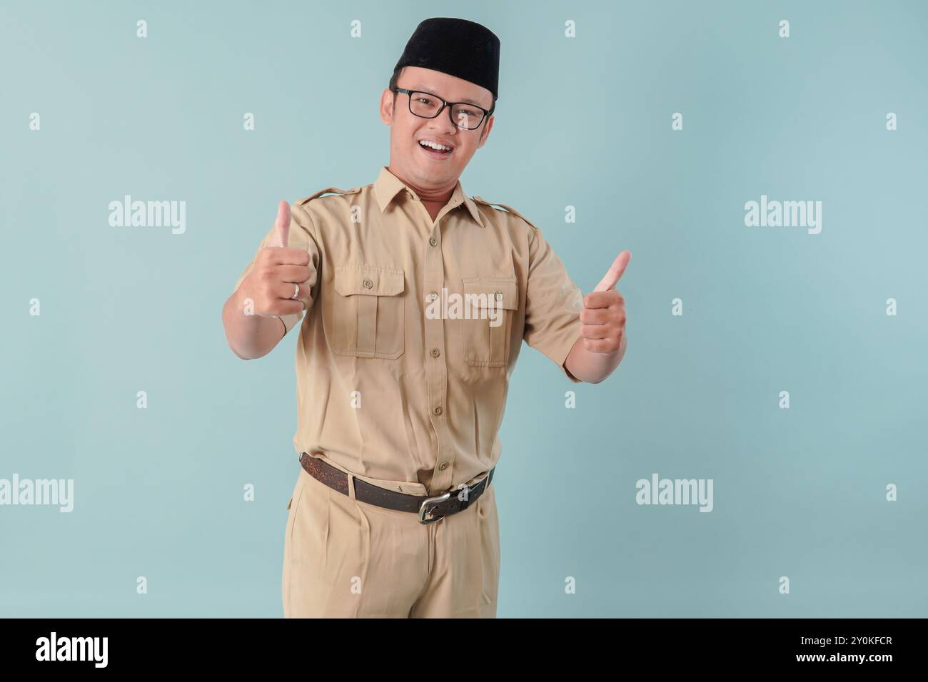 Handsome Indonesian government worker man wearing khaki uniform smiling ...