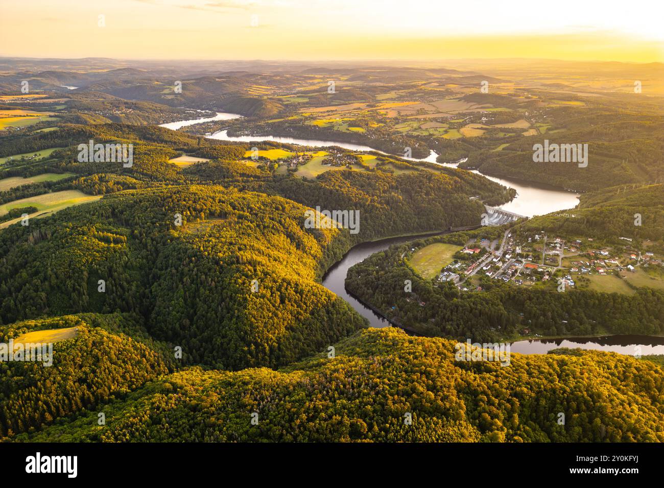 Aerial view of Slapy Water Reservoir at sunset, surrounded by lush ...