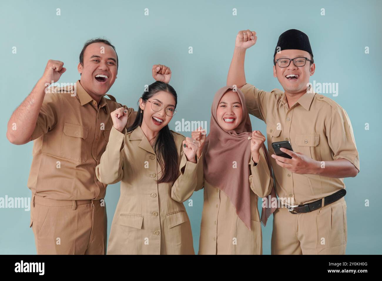 Four Indonesian government workers wearing khaki uniform smiling to the ...