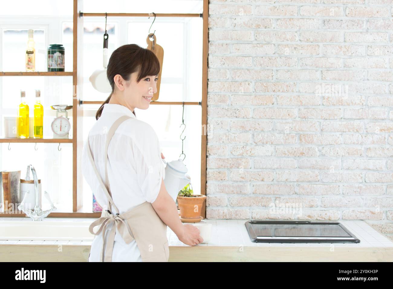 Housewife wearing an apron in the kitchen Stock Photo - Alamy