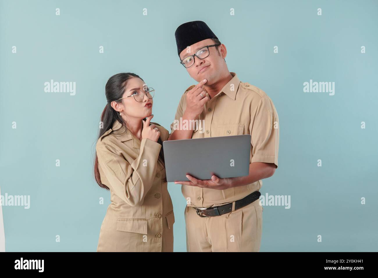 Thoughtful government worker couple wearing khaki uniform holding ...
