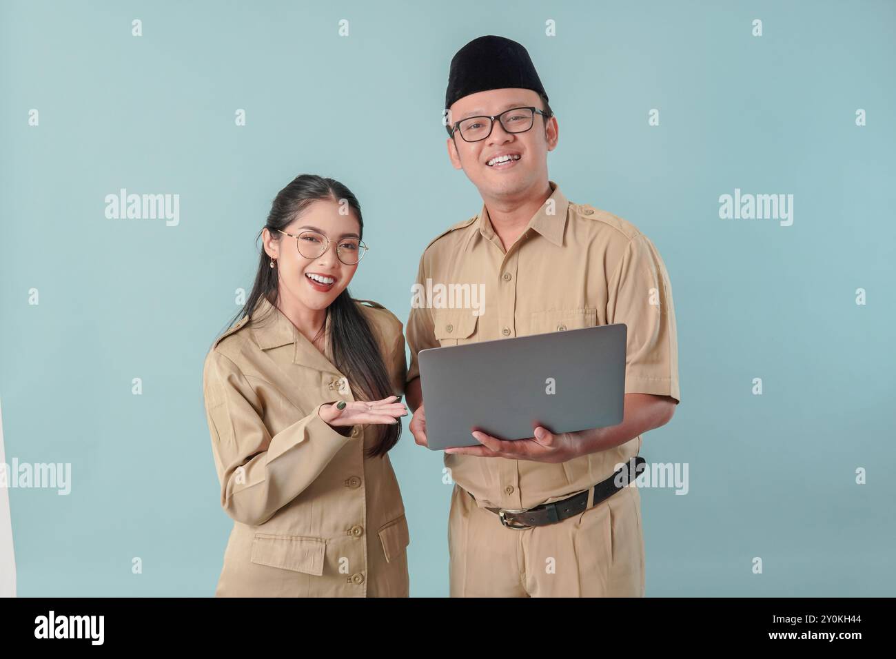 Joyful government worker couple in khaki uniform holding and presenting ...