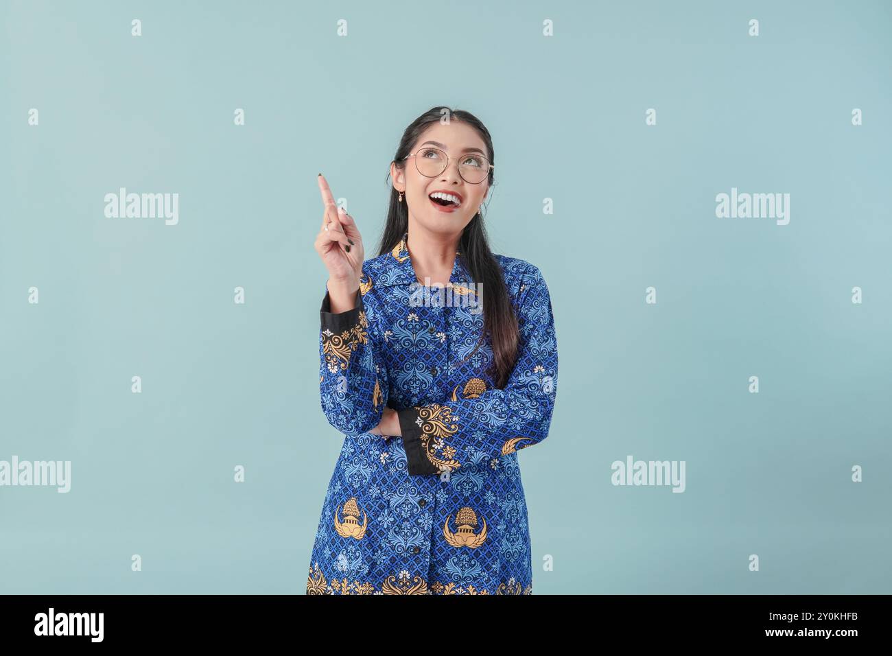 Happy government worker woman wearing blue batik uniform and glasses ...