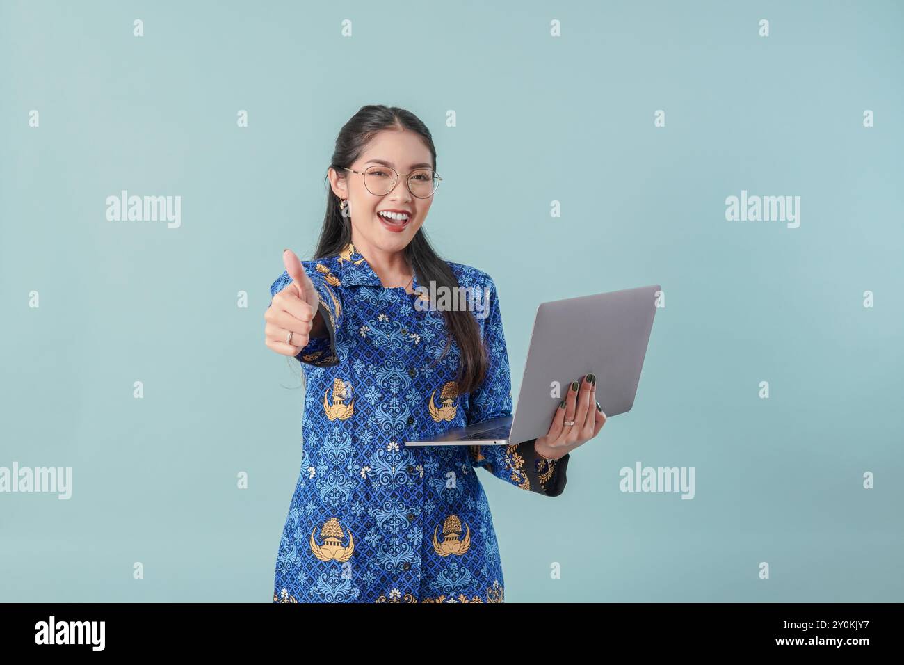 Government worker woman in blue batik uniform and glasses holding ...