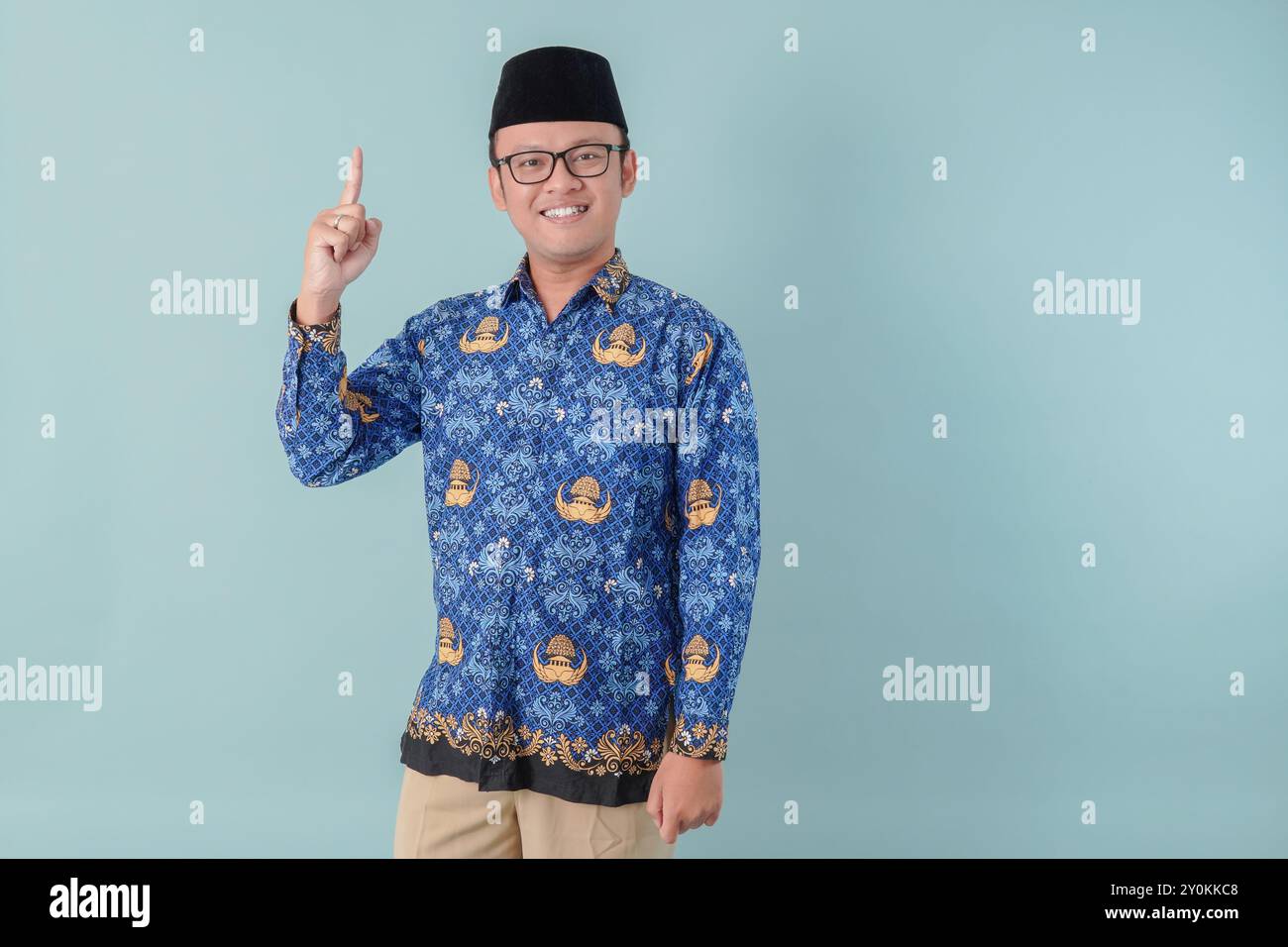 Happy government worker man wearing blue batik uniform pointing to the ...