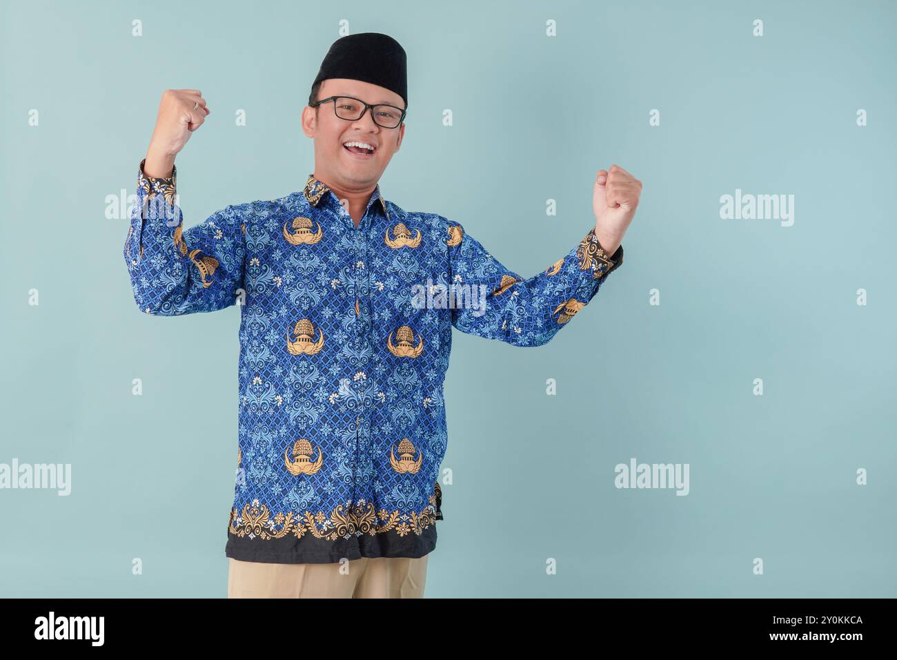 Excited Indonesian government worker man wearing blue batik uniform ...
