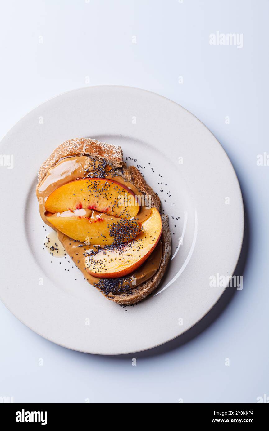 Peanut butter toast with peach and seeds, top view. Vegan healthy snack ...