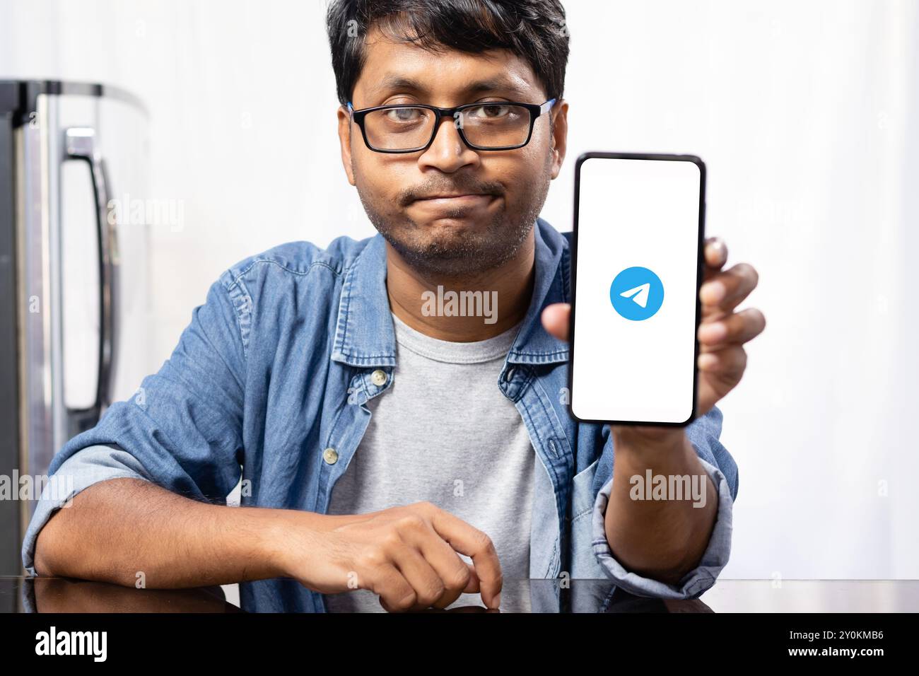 An Indian ethnicity male showing Telegram app logo on smart phone ...