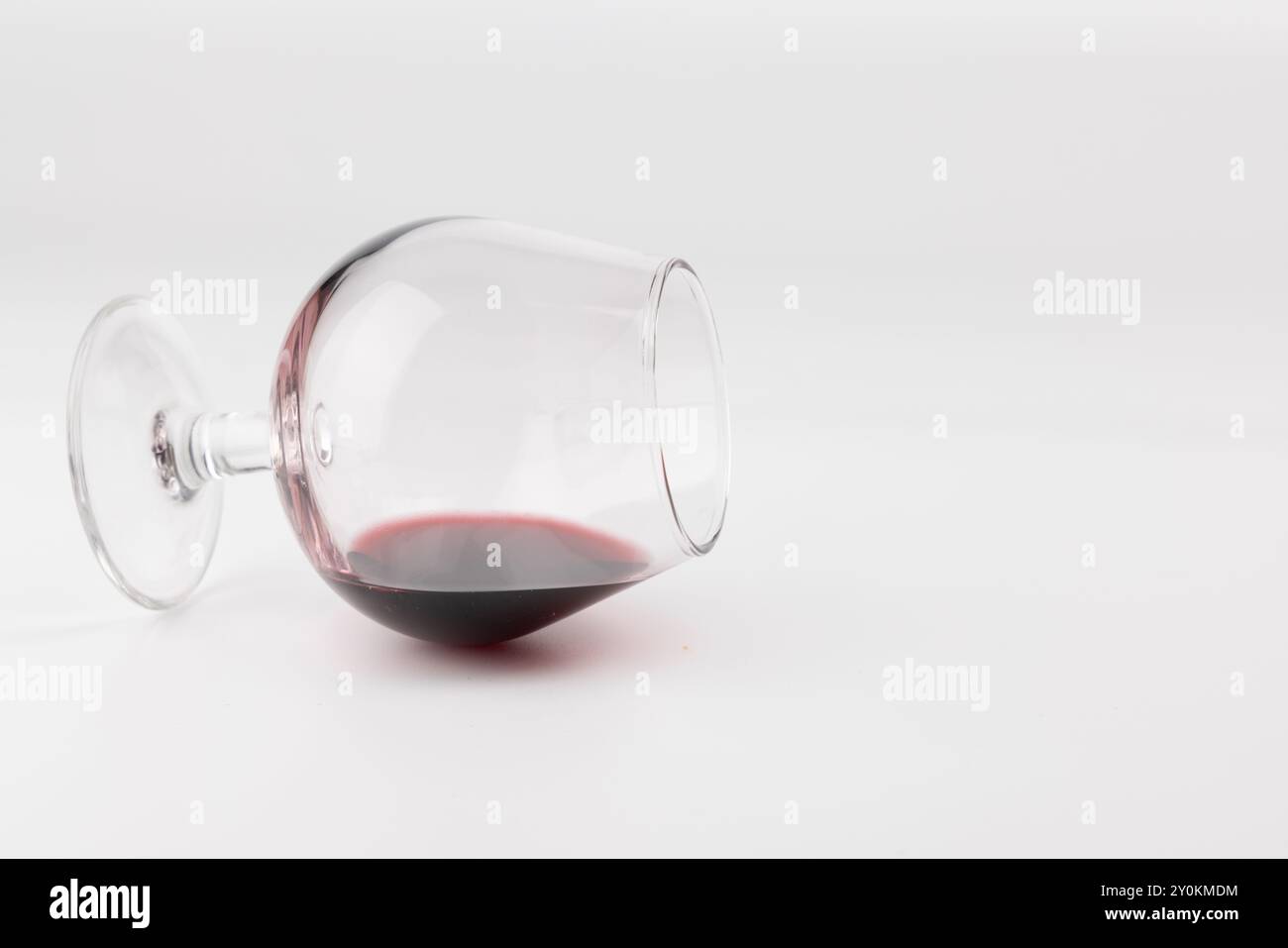 A partially filled wine glass leans against the body, positioned on the ...