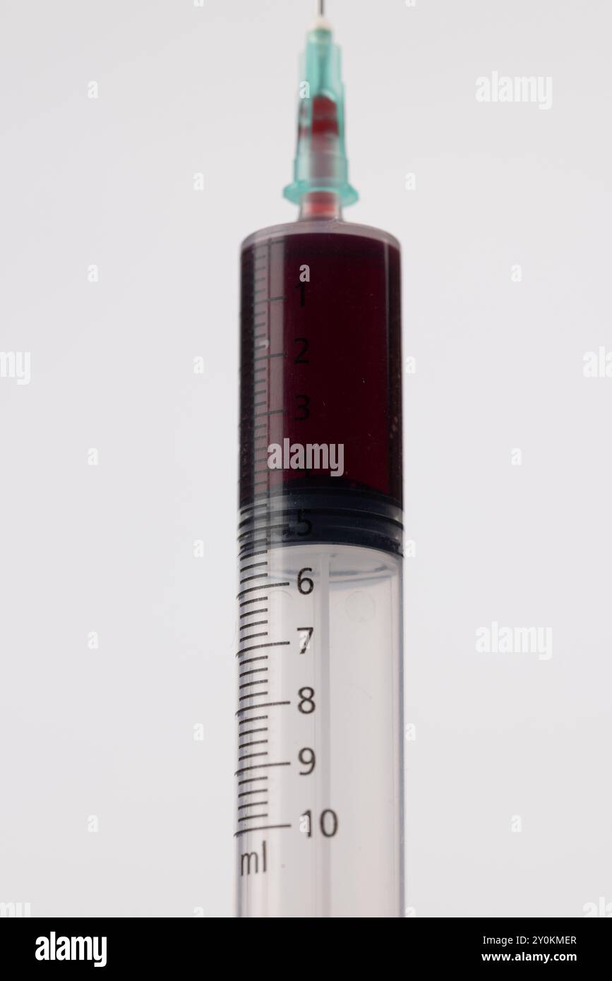 A vertical photo showcasing a detailed syringe filled with blood ...