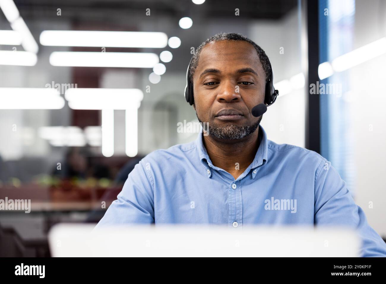 Serious businessman using headset for virtual meeting. Professional ...