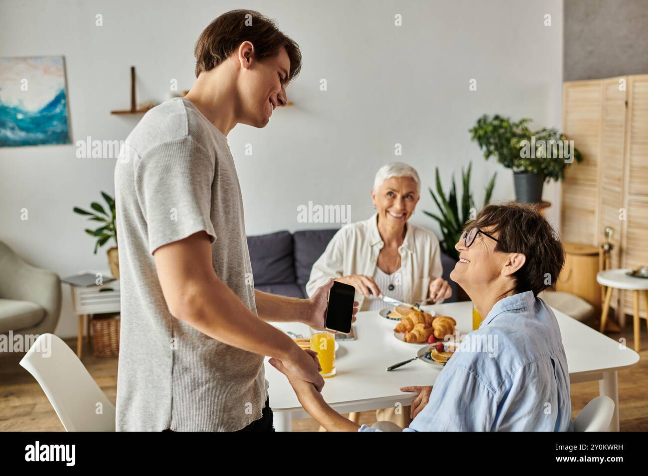 A loving LGBTQ family enjoys breakfast, sharing smiles and conversation ...