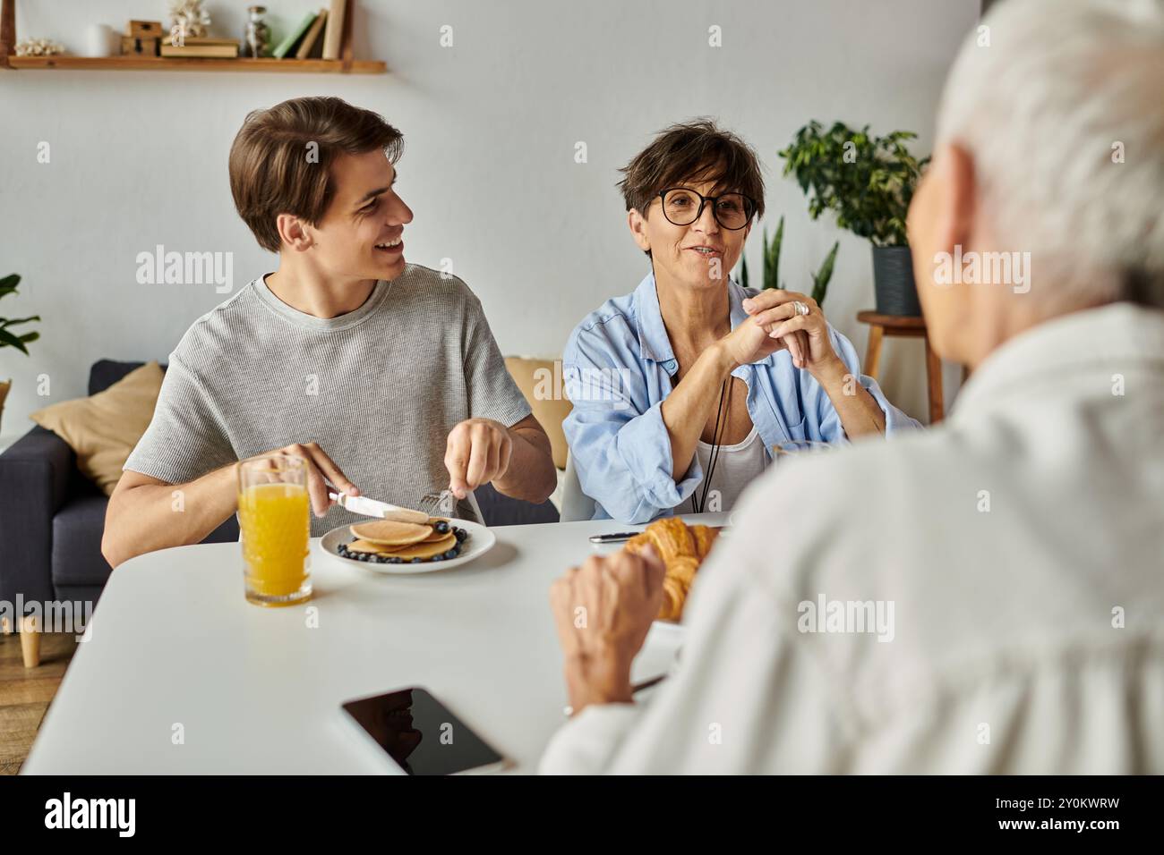 A joyful breakfast gathering featuring two moms and their adult son ...