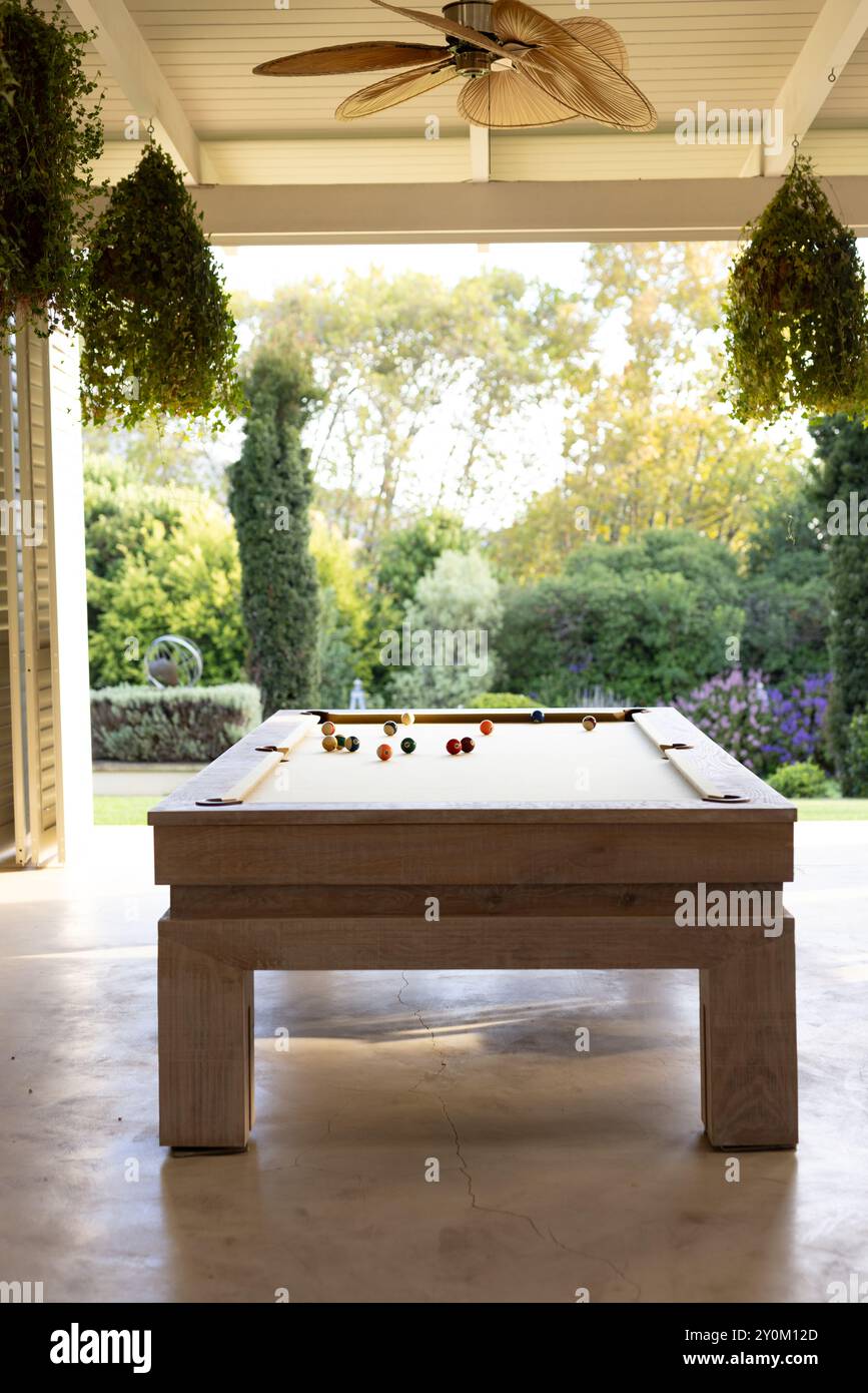 Playing pool on billiards table in bright, open patio area Stock Photo ...