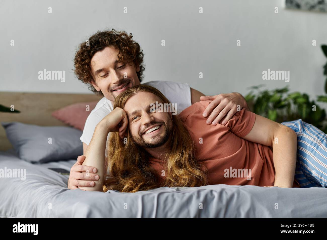 A joyful couple shares a heartfelt embrace on their serene bed Stock ...