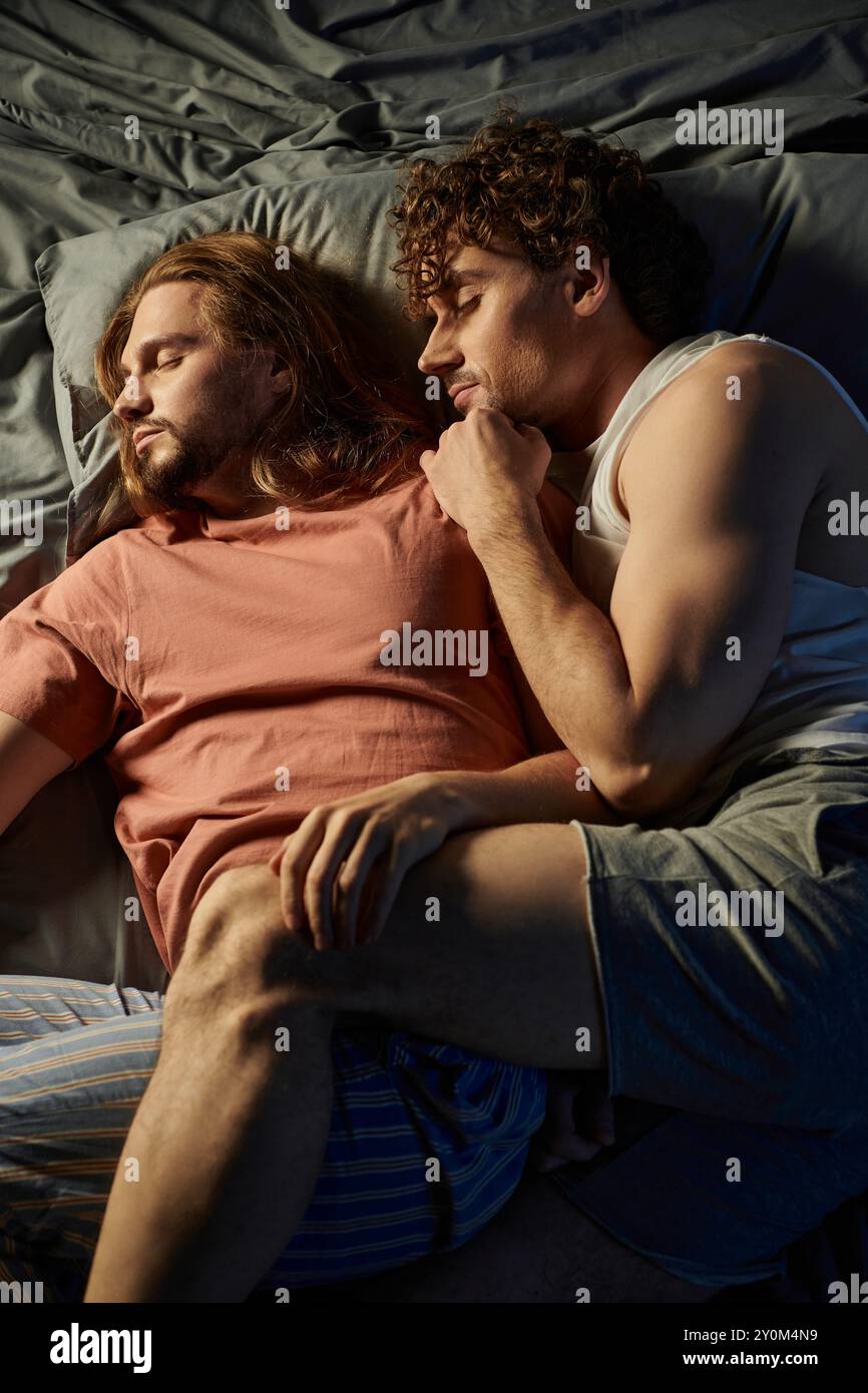 A handsome couple embraces tenderly while resting in bed Stock Photo ...