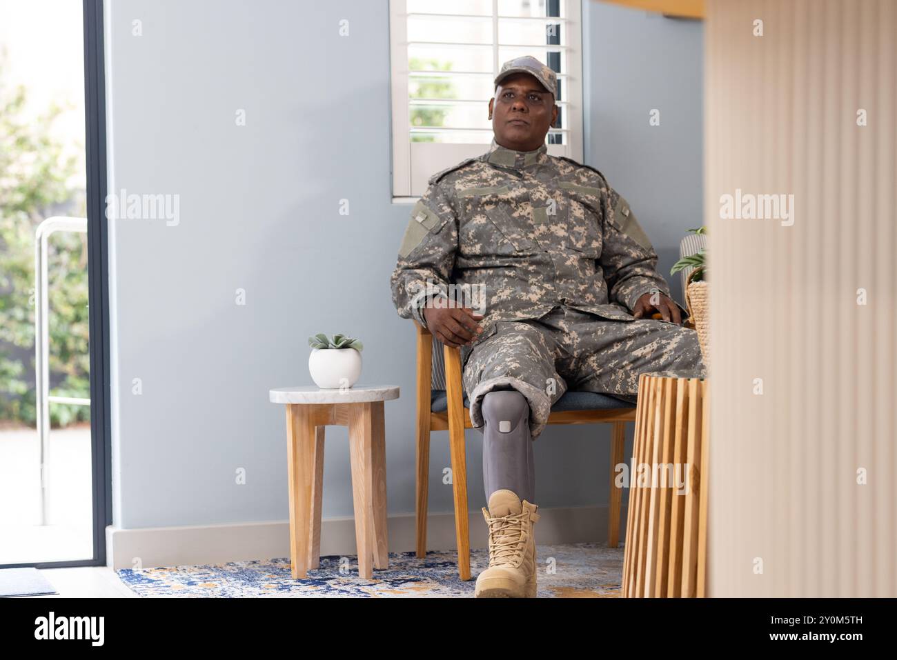 Veteran in military uniform sitting with prosthetic leg in modern ...