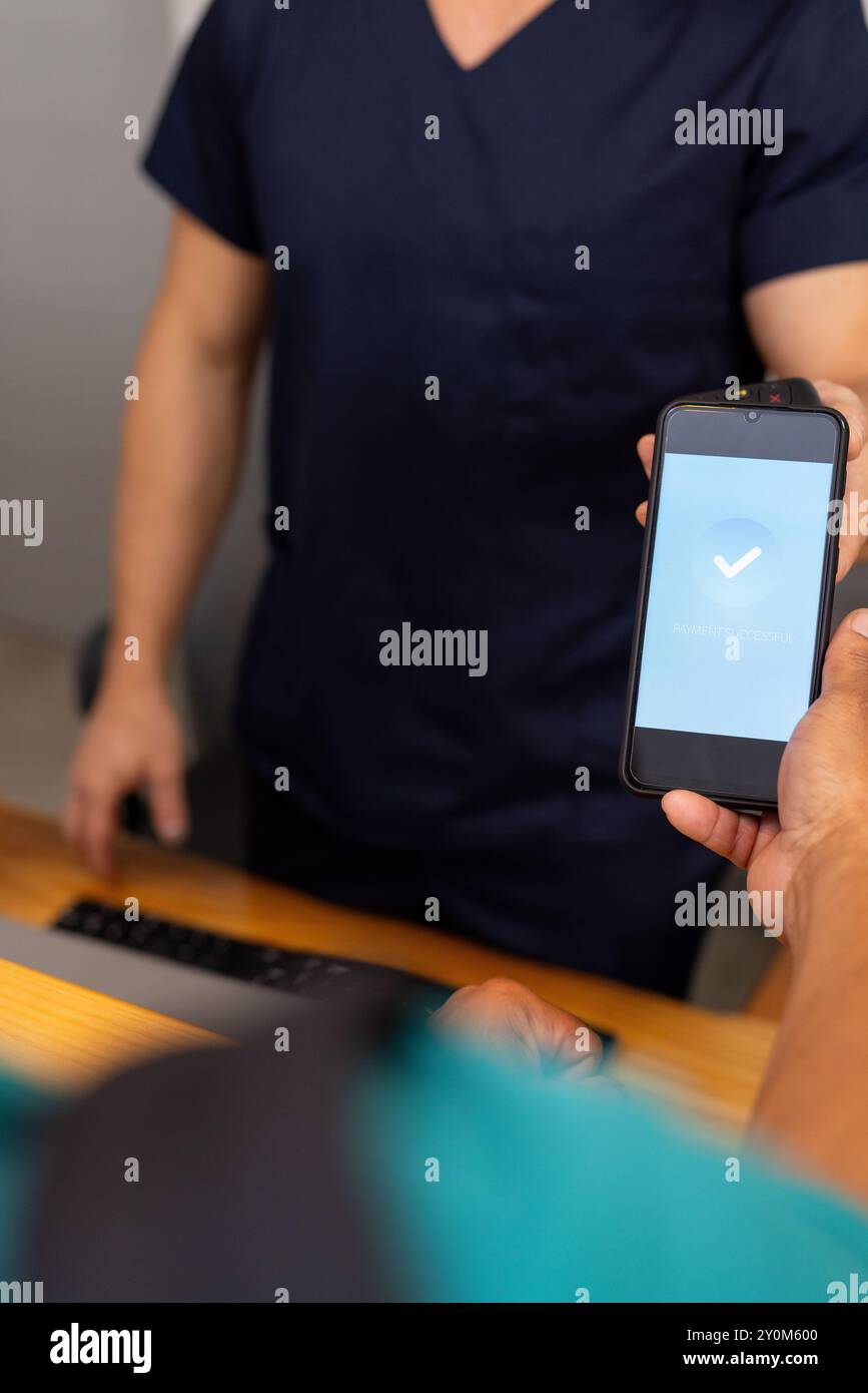 Handing smartphone with verification screen to person in scrubs at ...