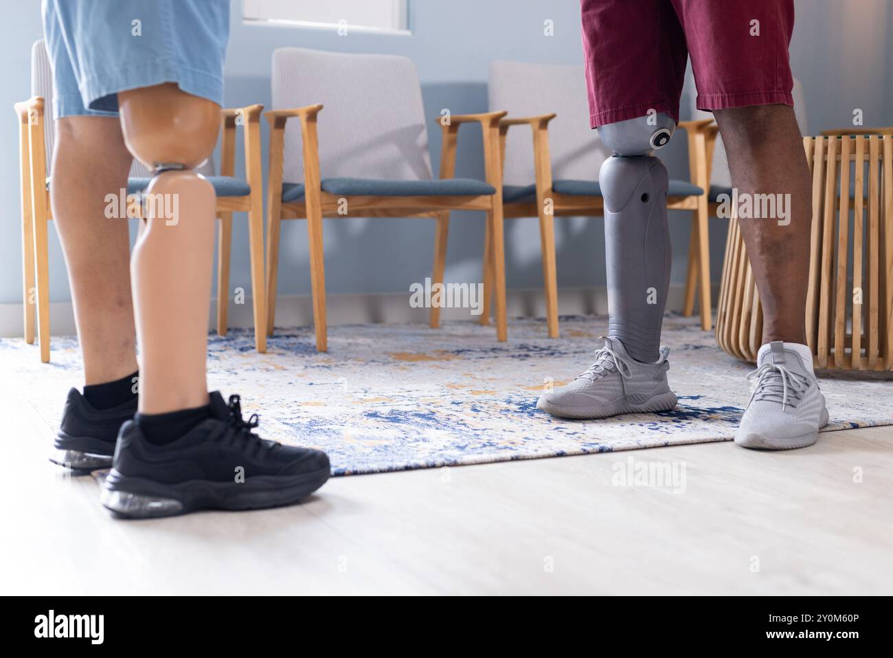 People with prosthetic legs standing and talking in modern clinic ...