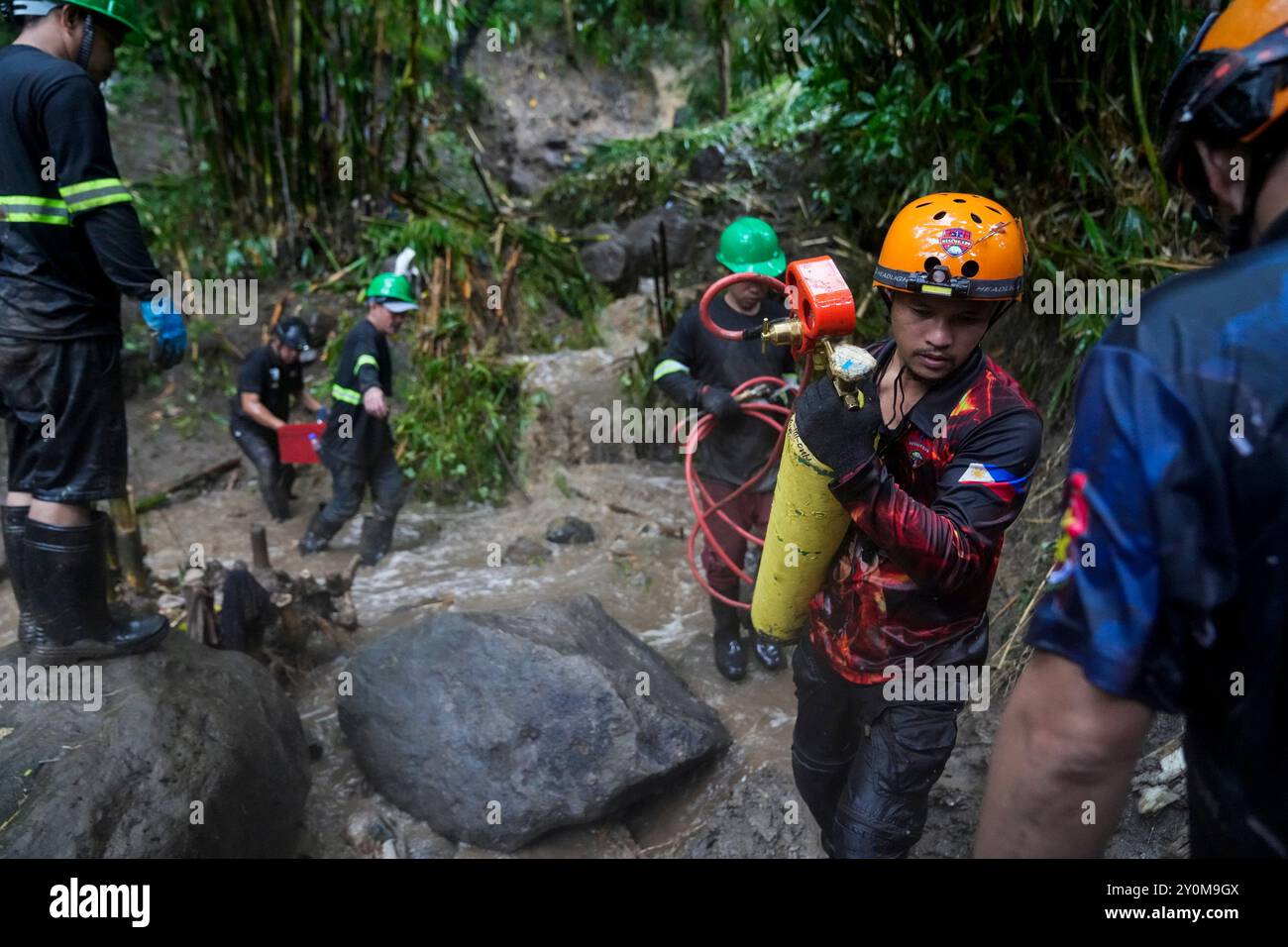 A rescuer carries equipment as they move to safer grounds during a halt ...