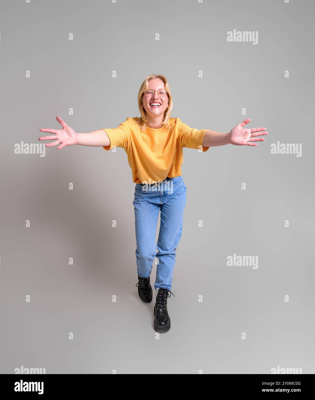 Cheerful female entrepreneur with arms outstretched offering hug while ...
