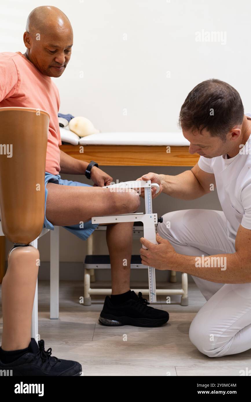 Measuring leg, prosthetist adjusting prosthetic limb for man in clinic ...