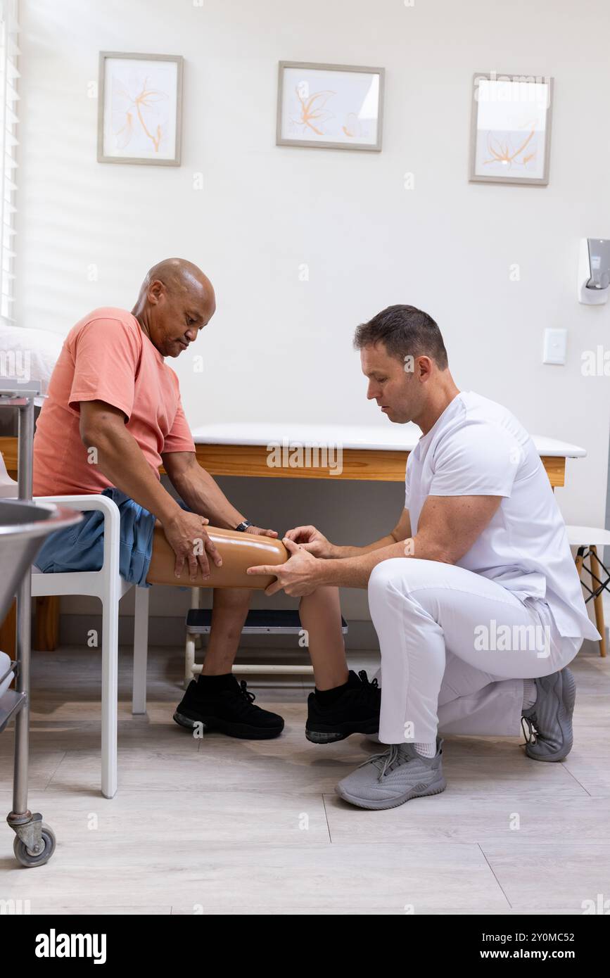 Technician fitting prosthetic leg for patient in medical clinic room ...