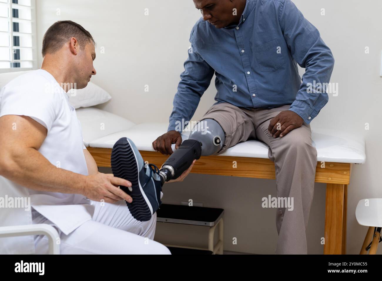 Adjusting prosthetic leg, healthcare professional assisting patient in ...