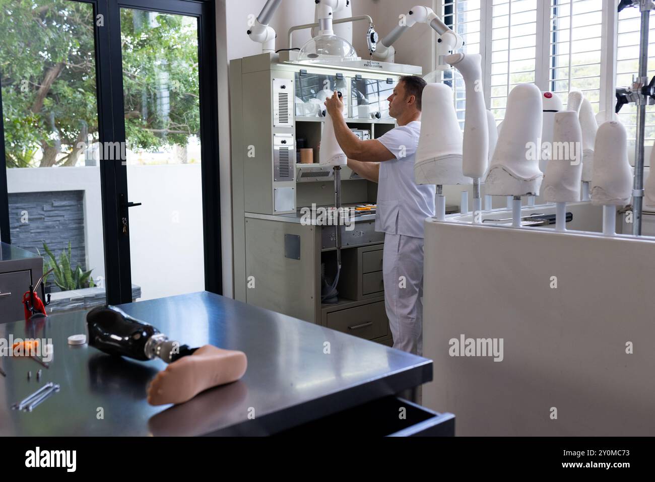 Technician in prosthetic lab working on artificial limb, using ...