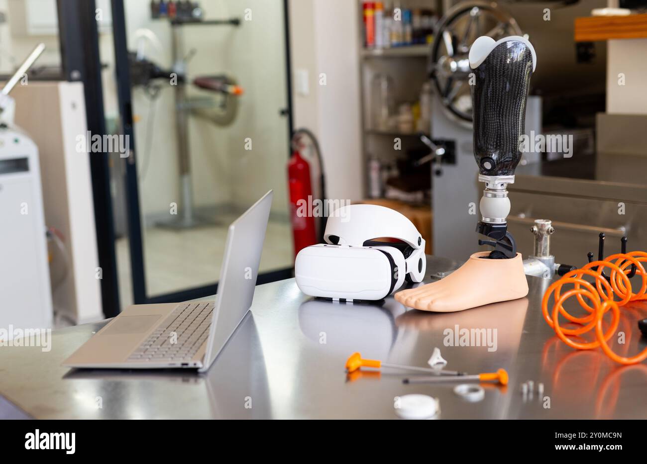 Prosthetic leg and VR headset on table in prosthetic lab with laptop ...