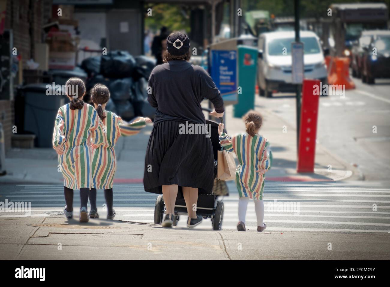 A view from behind of 3 modestly dressed orthodox Jewish sisters ...