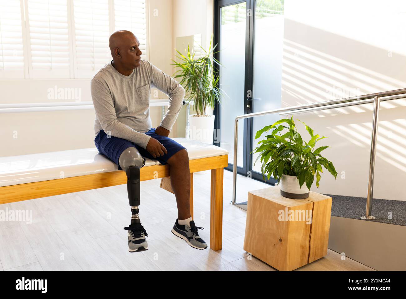 Sitting on bench in rehabilitation center, man with prosthetic leg ...