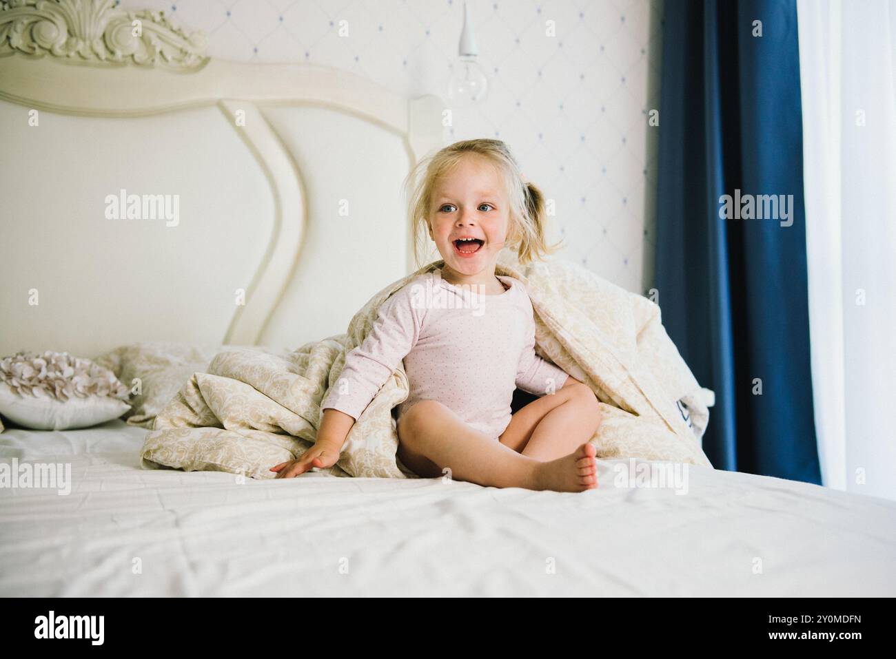 girl child waking up in the morning having fun and playing in bed Stock ...