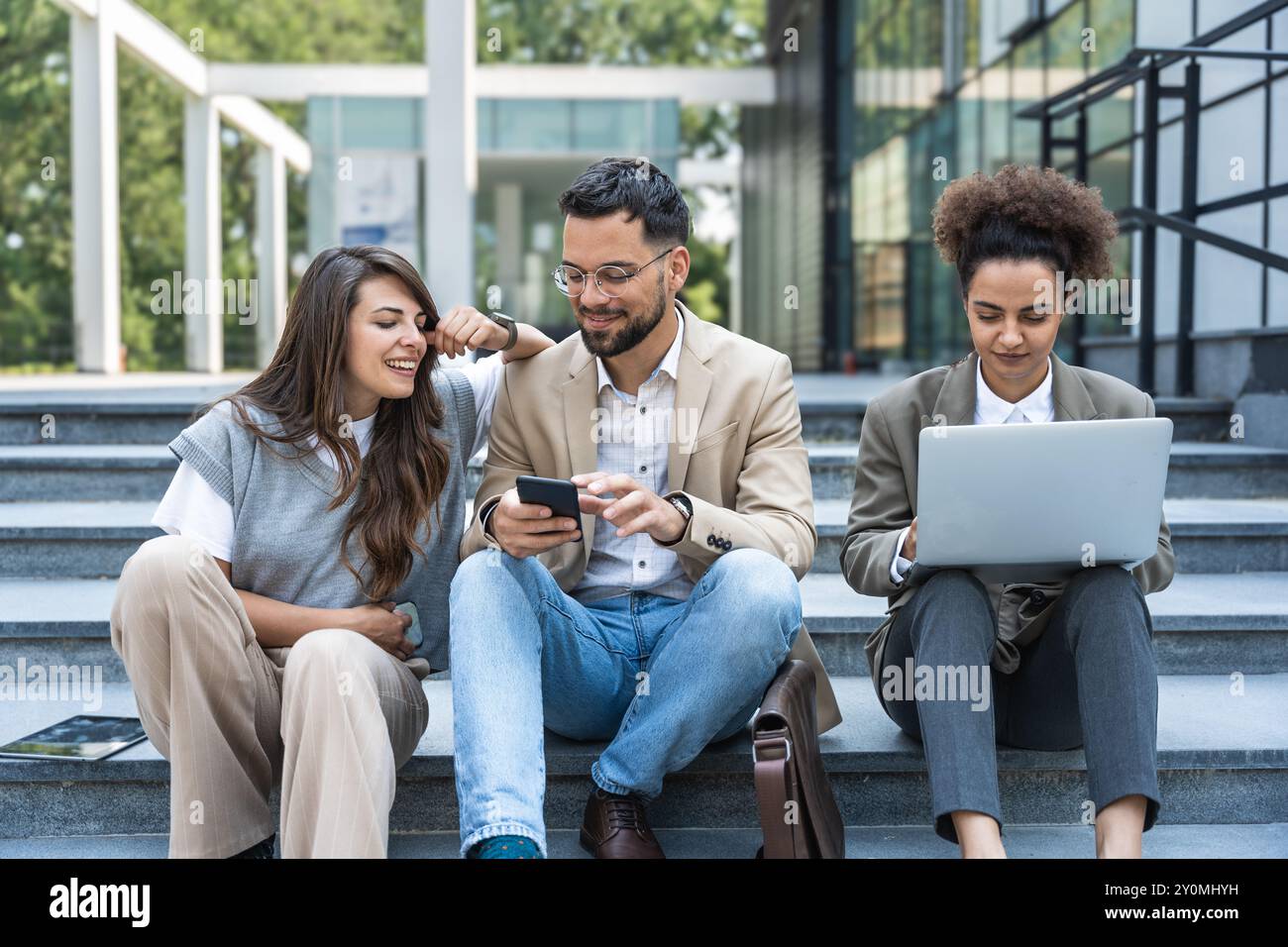 Three diverse business people working and talking focused and ...