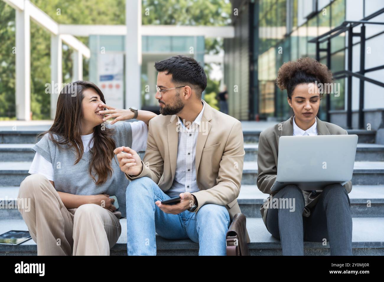 Three diverse business people working and talking focused and ...