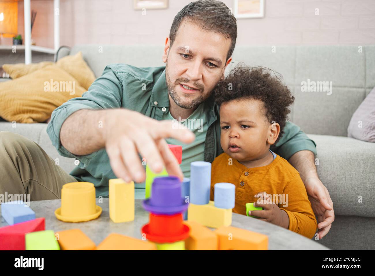 Multiracial family playing with colorful building blocks indoors Stock ...