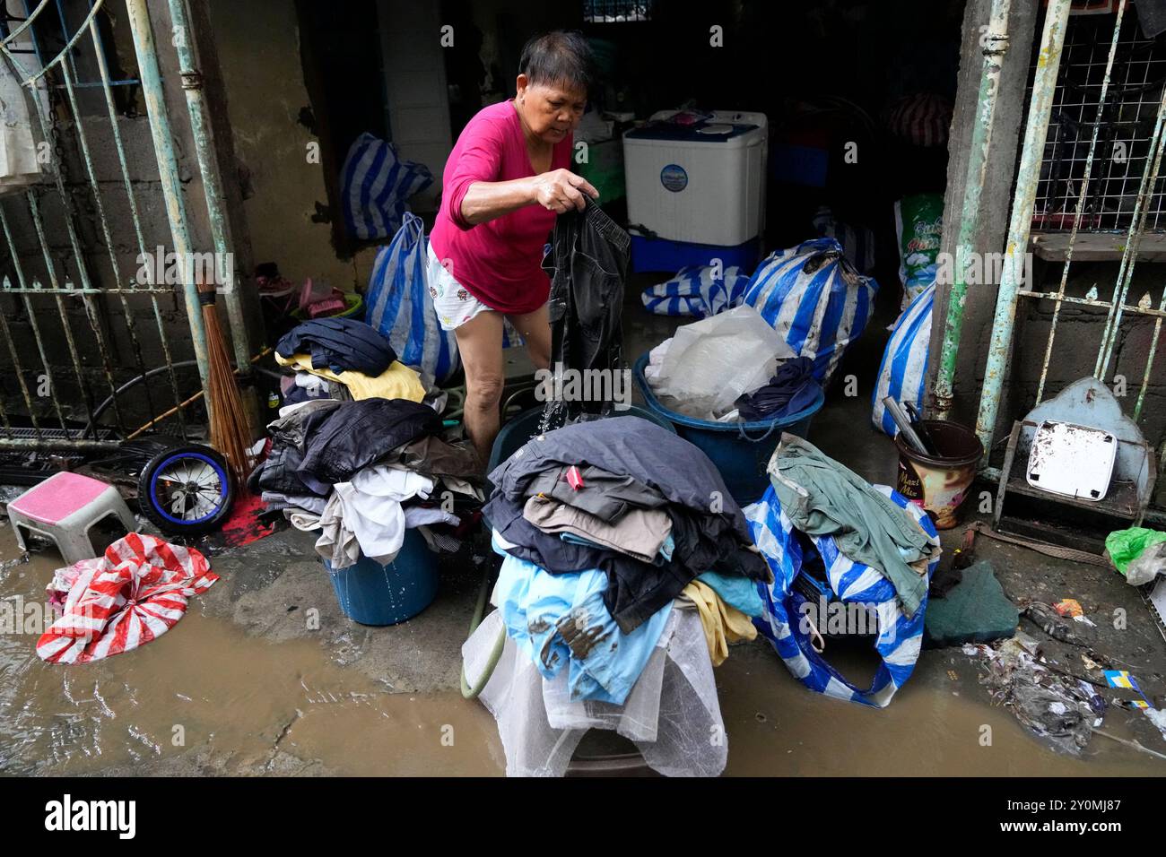 A resident cleans clothes after floods caused by Tropical Storm Yagi ...