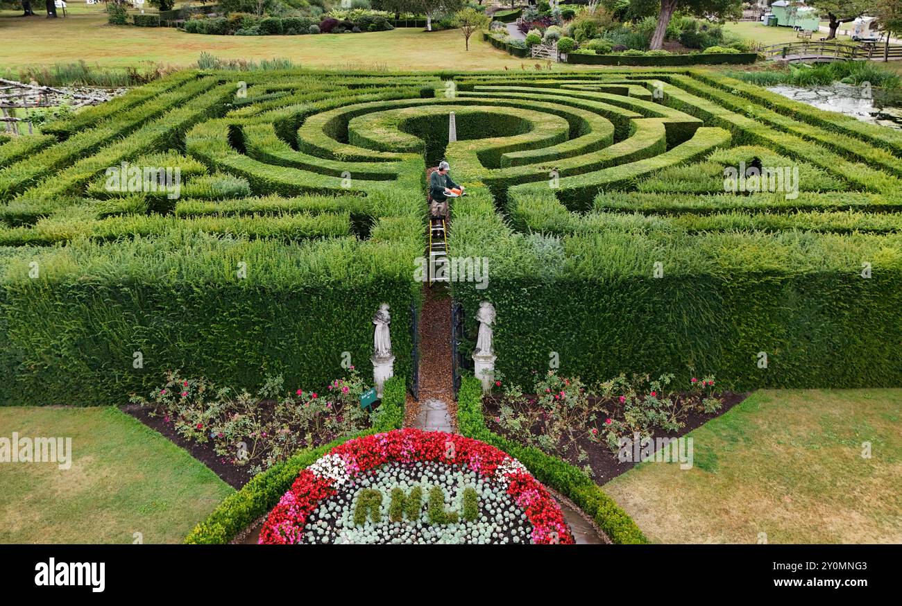 A gardener at Hever Castle tends to the bushes of the historic 120-year ...