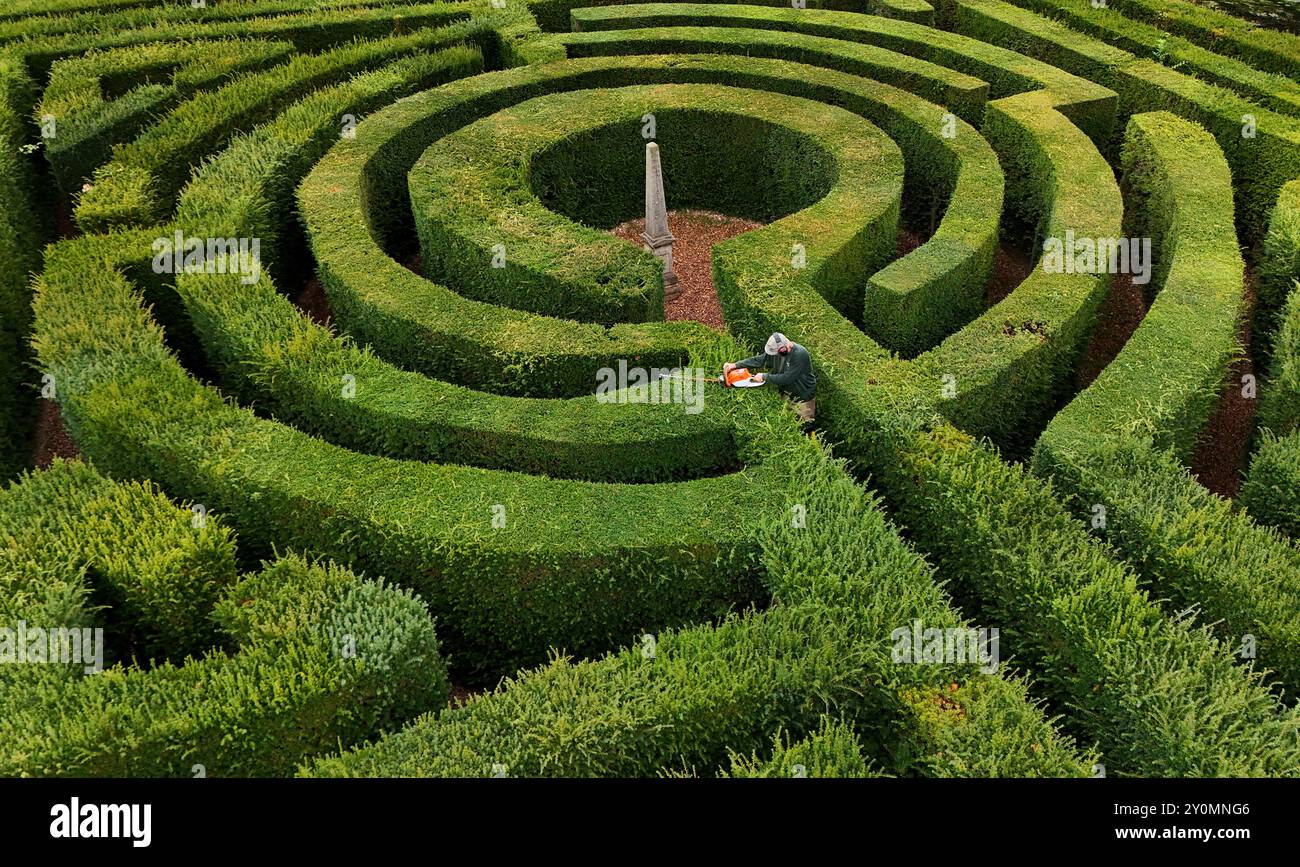 A gardener at Hever Castle tends to the bushes of the historic 120-year ...